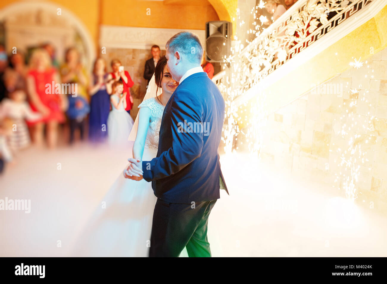 Happy young wedding couple dancing their first dance with different ...