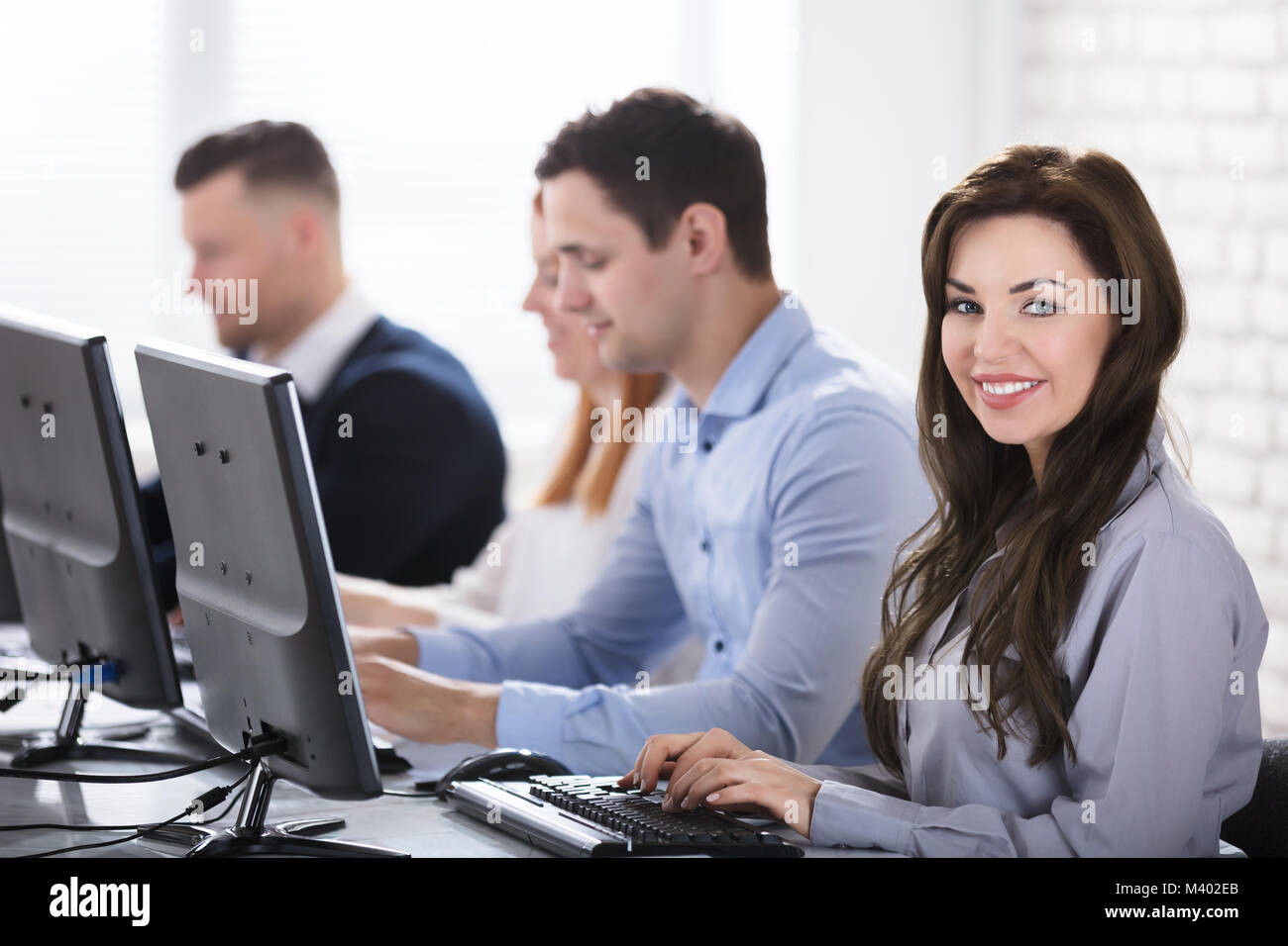 Young Business People Using Computer At Workplace In Office Stock Photo ...