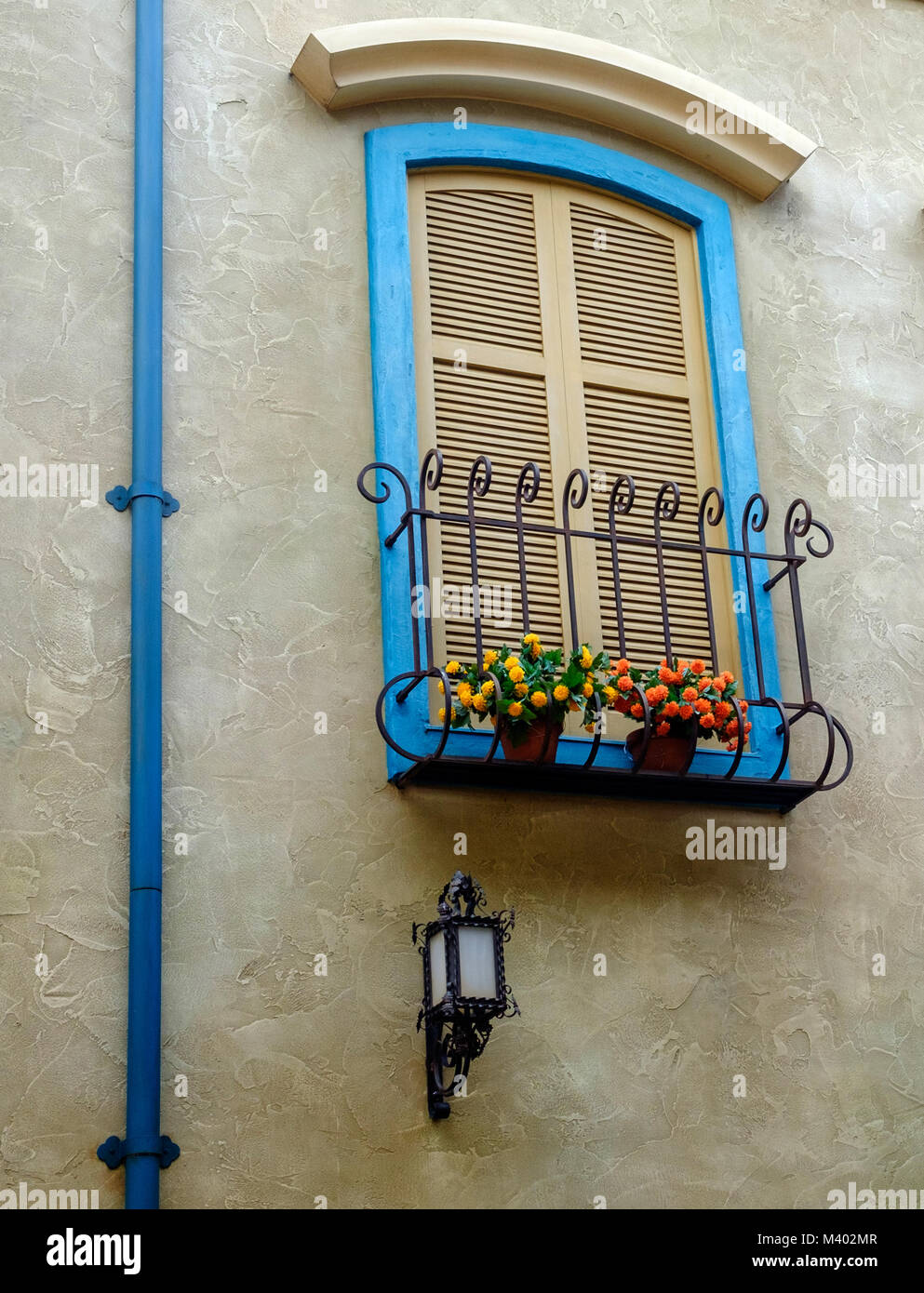 Shuttered window with wrought iron window box, bright flowers & blue ...