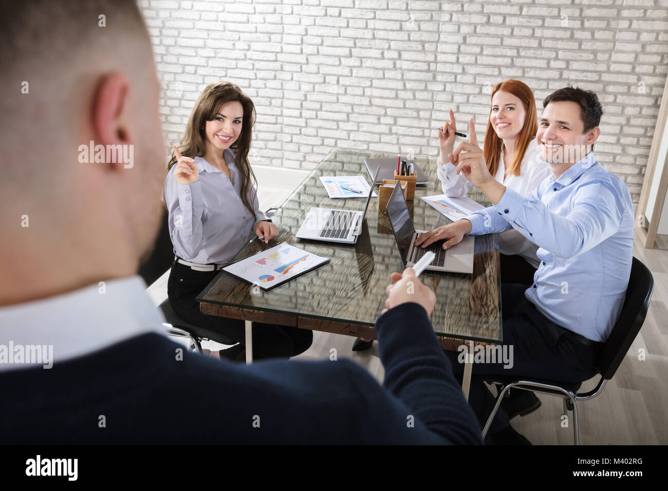 Businessman Asking Question To His Colleagues During Presentation In ...