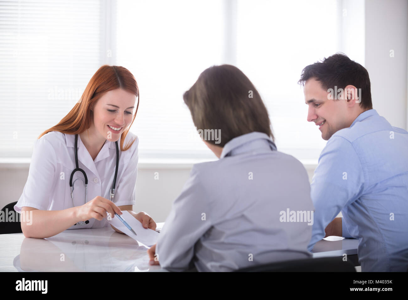 Young Female Doctor Giving The Prescription Paper To The Patient In ...