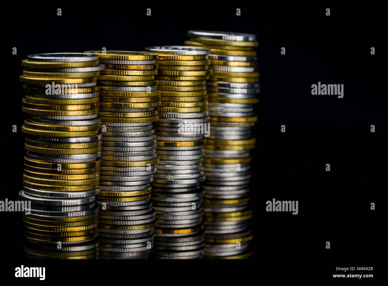 Macro shot detail of golden and silver color coin stacks on dark ...