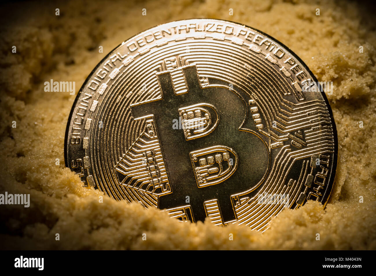 close up of bitcoin half in the sand concept of mining or price ...