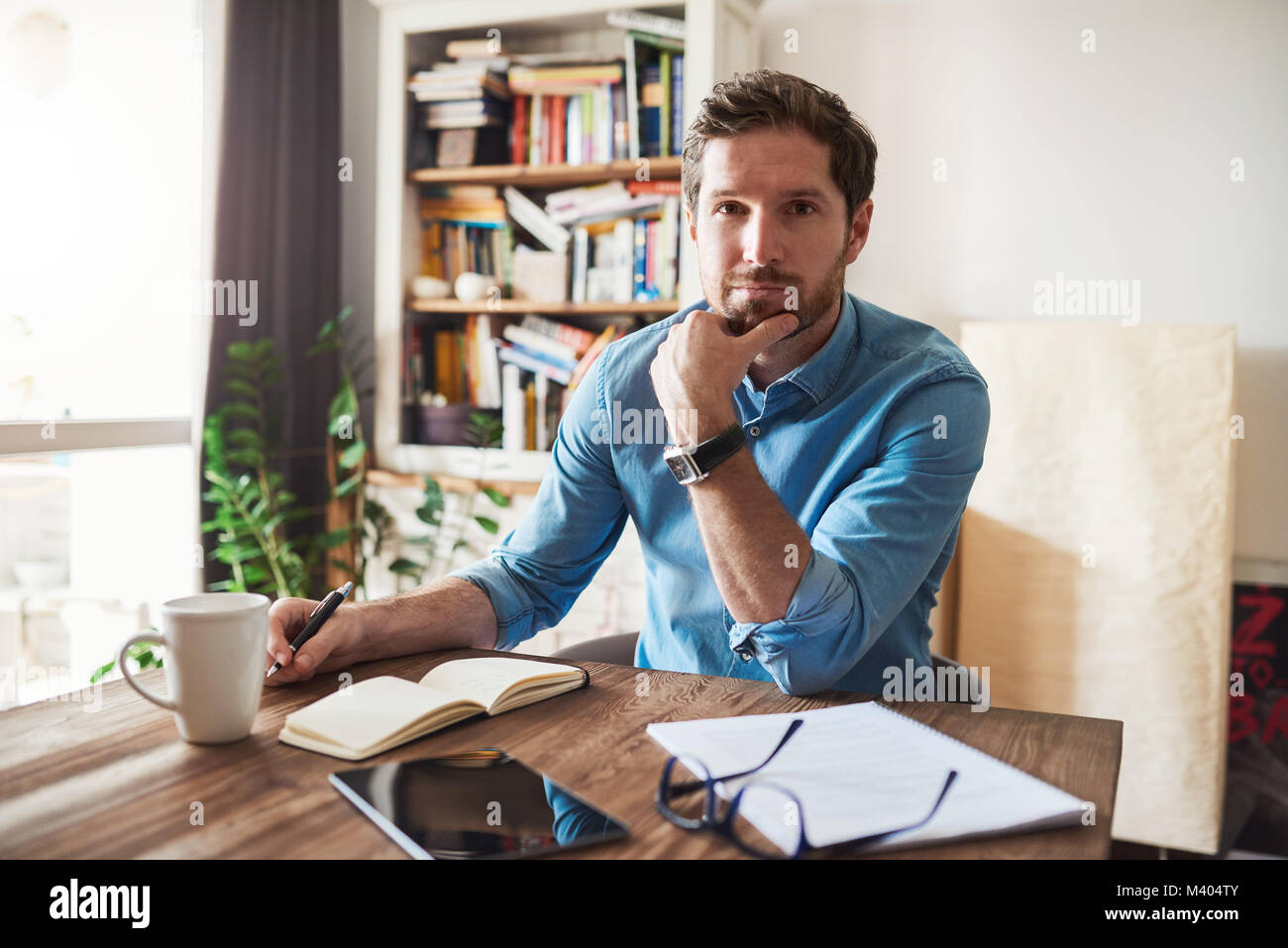 Young man working at his living room table at home Stock Photo - Alamy