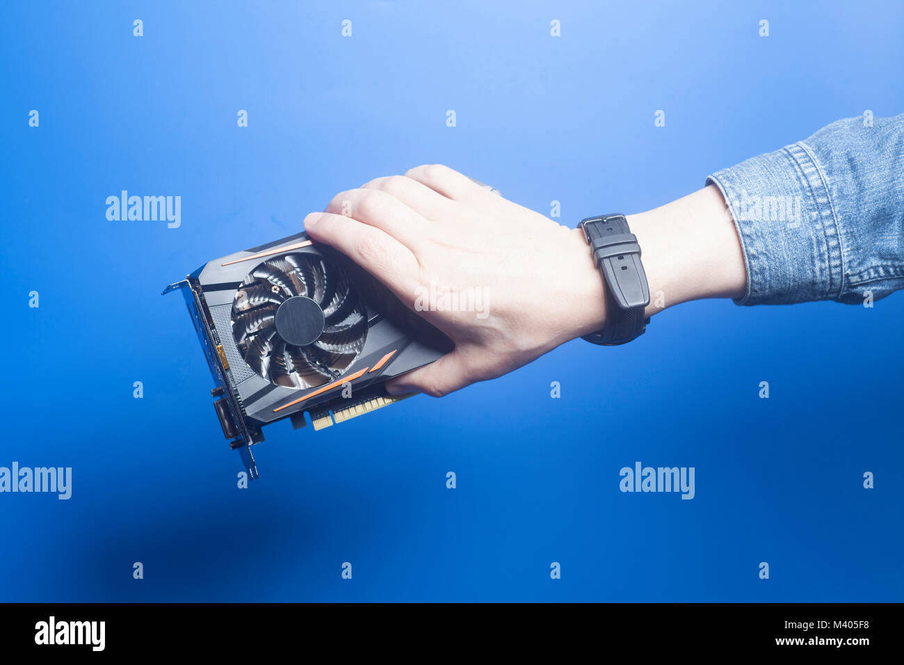 Graphic video card holding hand on blue background Stock Photo - Alamy