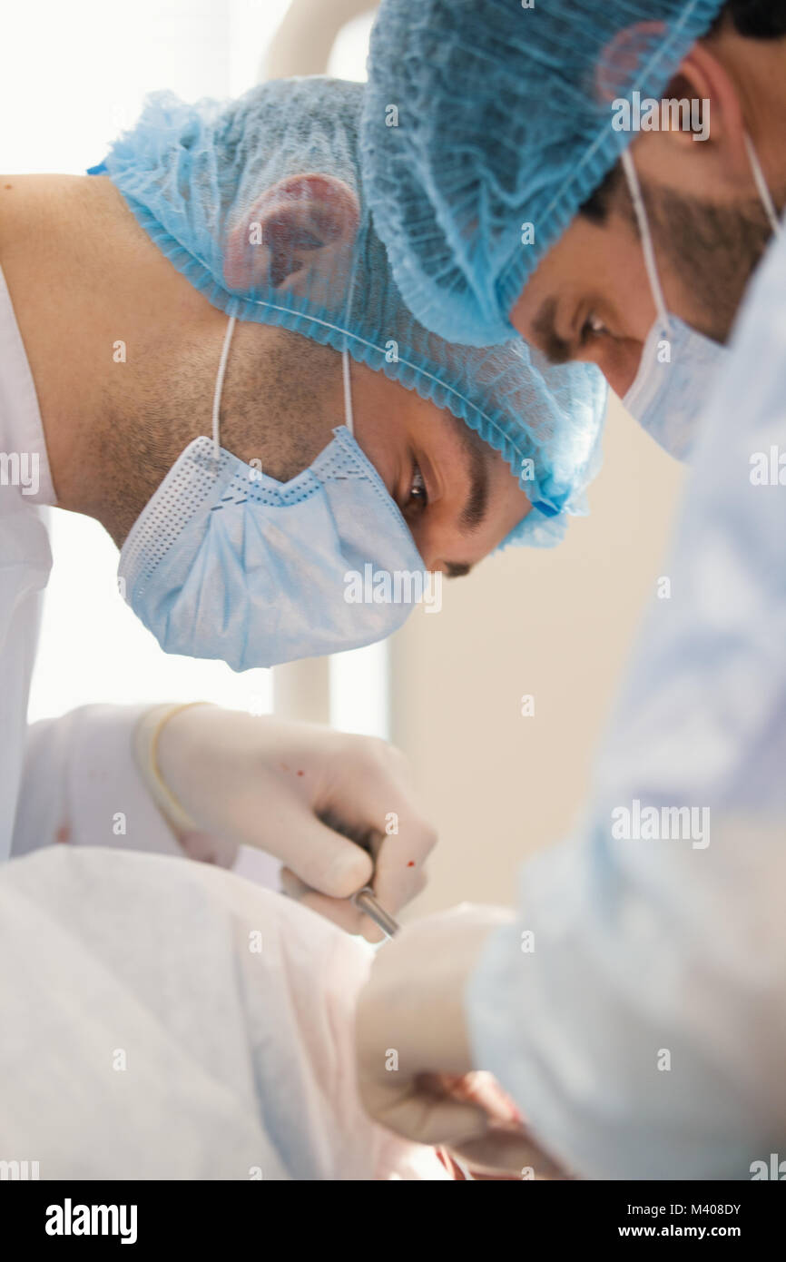Two surgeons in blue robes make operation in surgery room Stock Photo ...