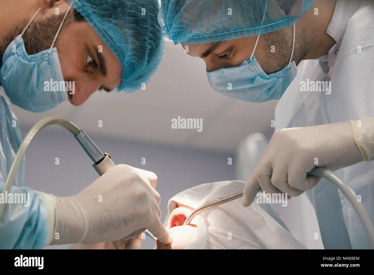Dentistry surgeons in surgery room makes stomatology operation for ...
