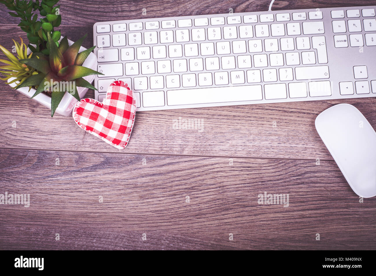 Working table with a keyboard, mouse and heart from above. Copy space ...