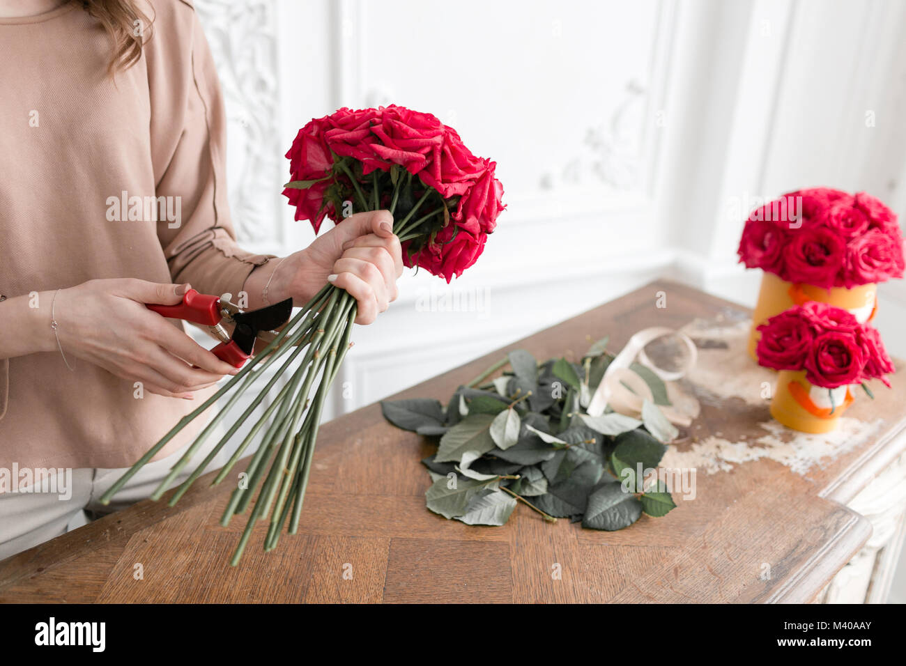 Young woman florist arranging plants in flower shop. People, business ...