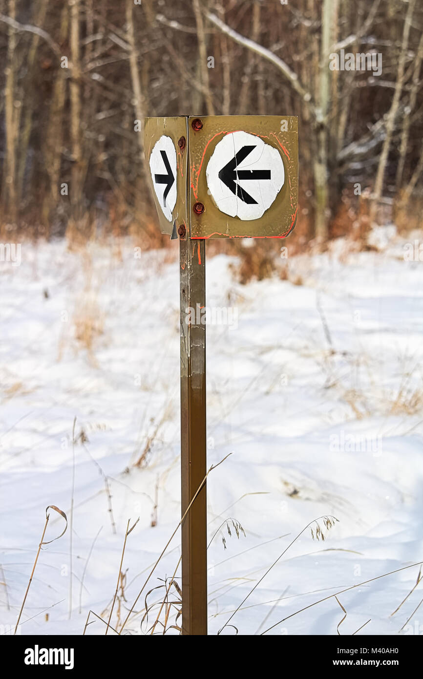 A white arrow direction sign along a hiking path Stock Photo - Alamy