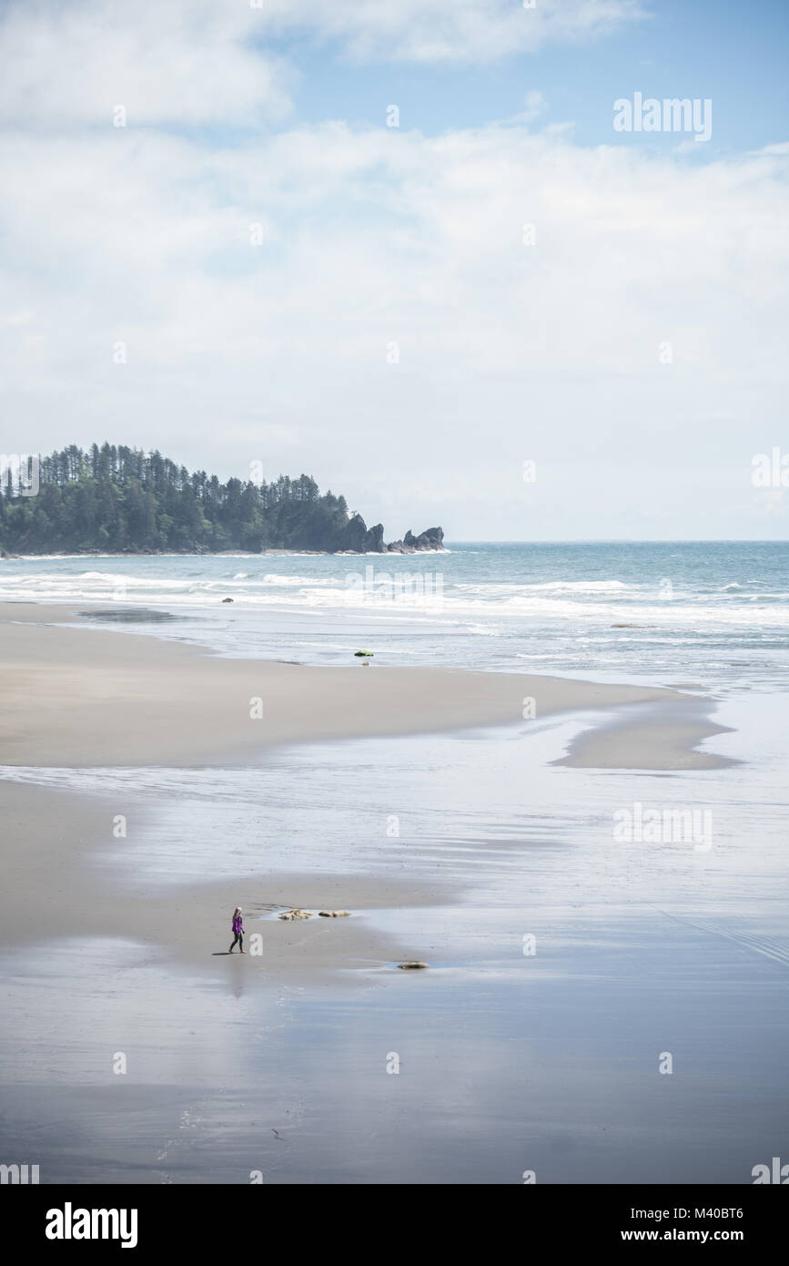 A young woman walks along Ruby Beach at low tide in Forks, Washington ...