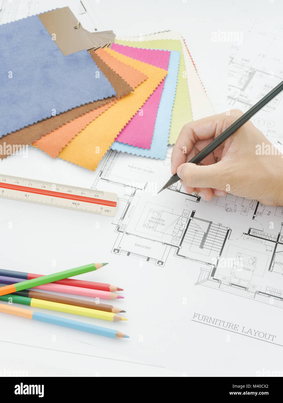 View of hand writing on architectural drawing with fabric sample, scale ...