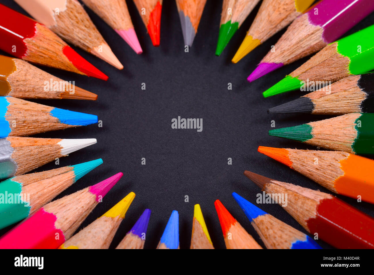 Circular colored pencils on black background Stock Photo - Alamy