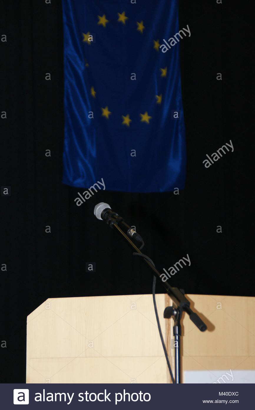 EU flag hanging behind a podium with a microphone at the start of a ...