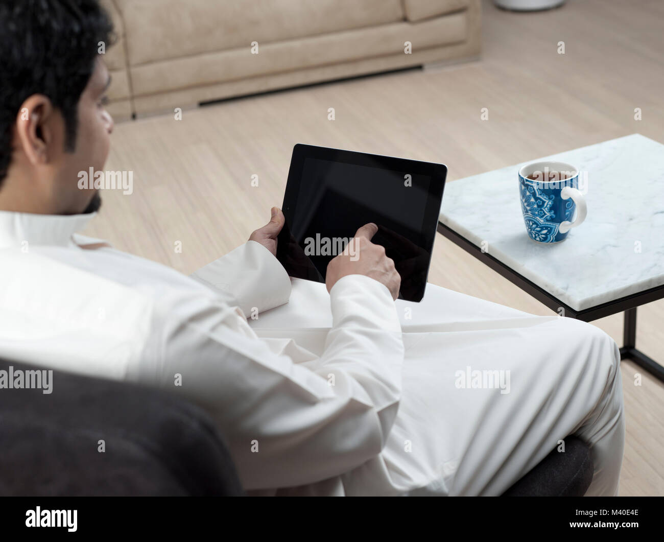 Saudi Arabian Man Using Tablet at Home Environment Stock Photo - Alamy