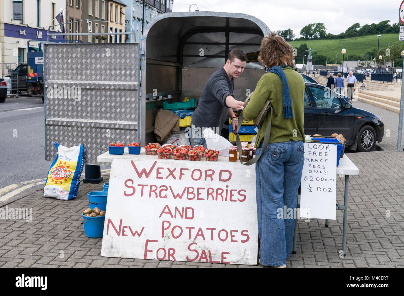 A customer buying fresh local produce from a food market stall in ...