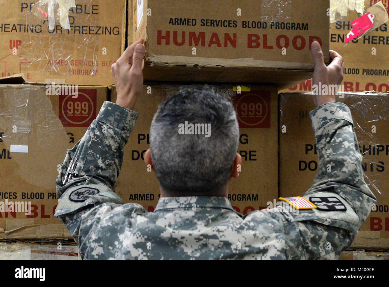 Army Lt. Col. Jose Quesada lifts a shipping container for blood ...