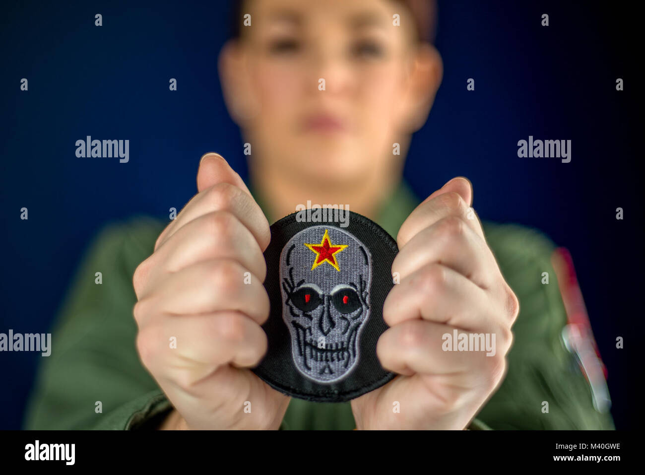 Capt. Danielle Esler, 64th Aggressor Squadron, holds the unit's patch ...