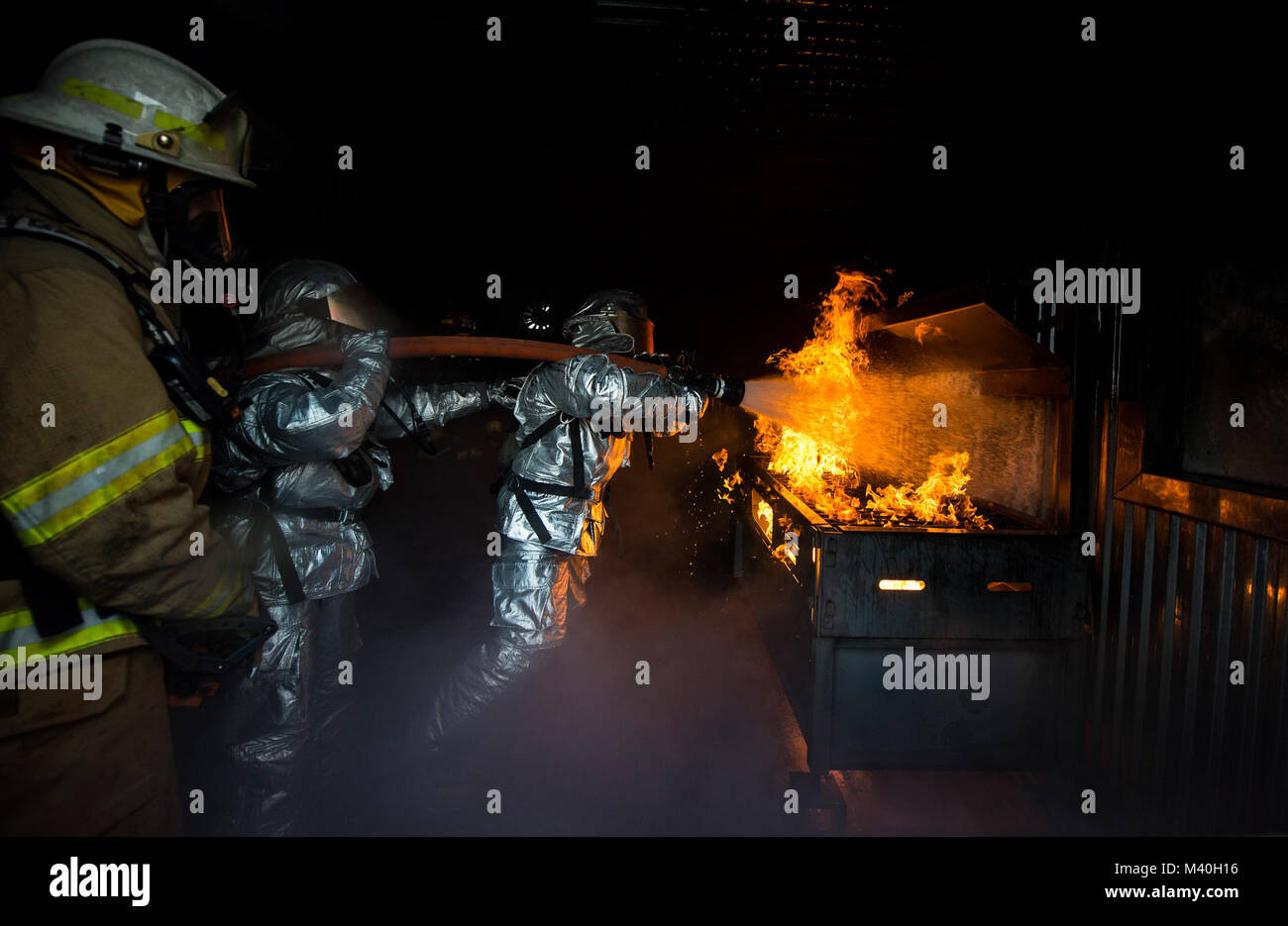 U.S. Air Force firefighters fight flames during a controlled building ...