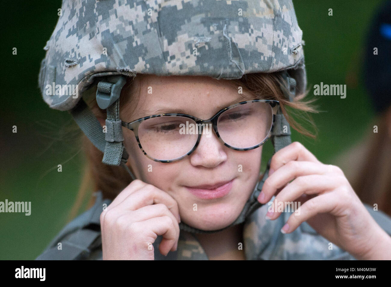 Jillian Thomas, 11, tries on a soldier’s helmet while visiting the ...