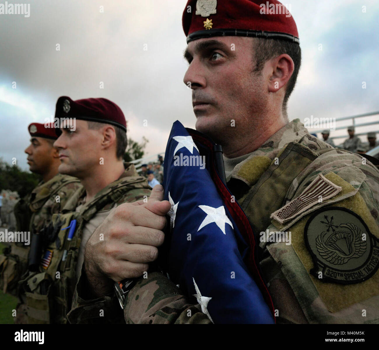 Maj. John Traxler carries the American flag before "Reveille" during a ...