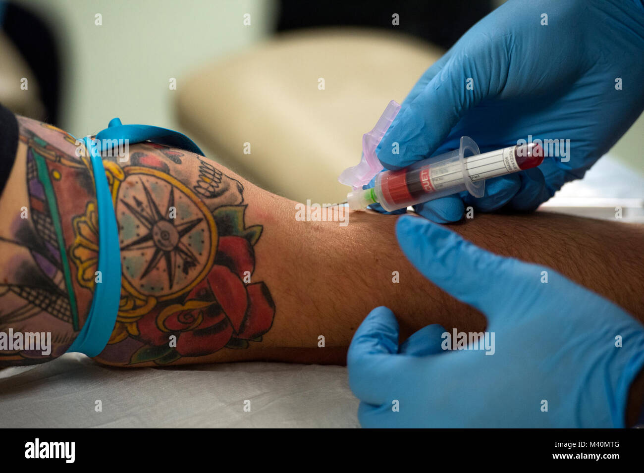 A student practices drawing blood samples from another student at the ...