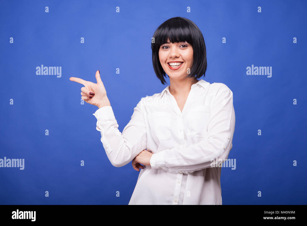 Happy smiling woman poiting Stock Photo - Alamy