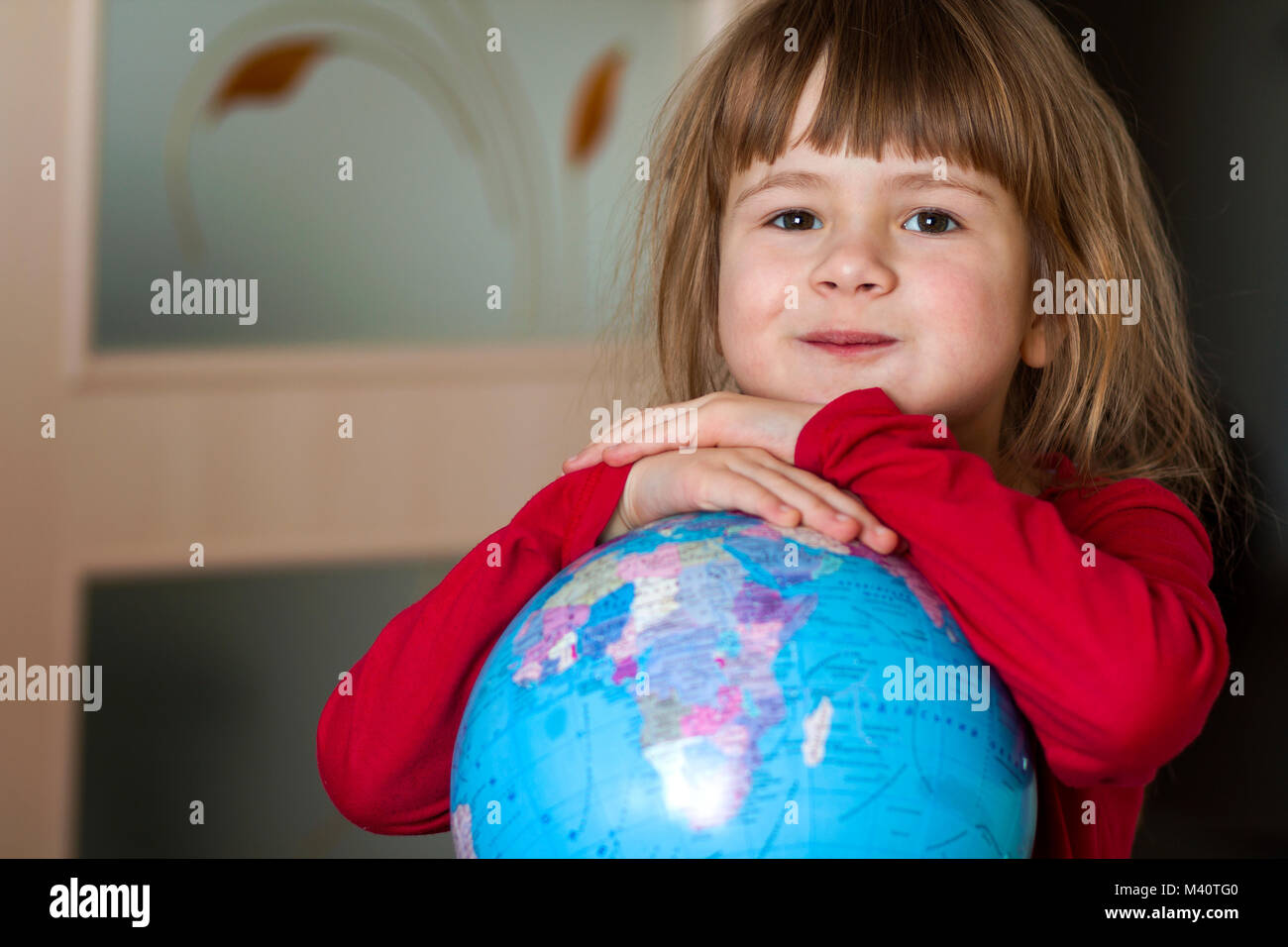 Portrait of the cute little girl hugging the earth globe. Education and ...