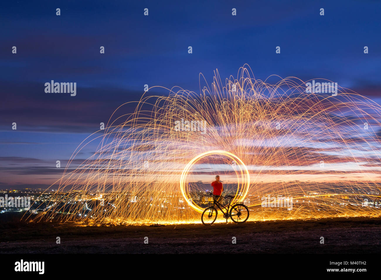 Firework showers of hot glowing sparks from spinning steel wool over ...
