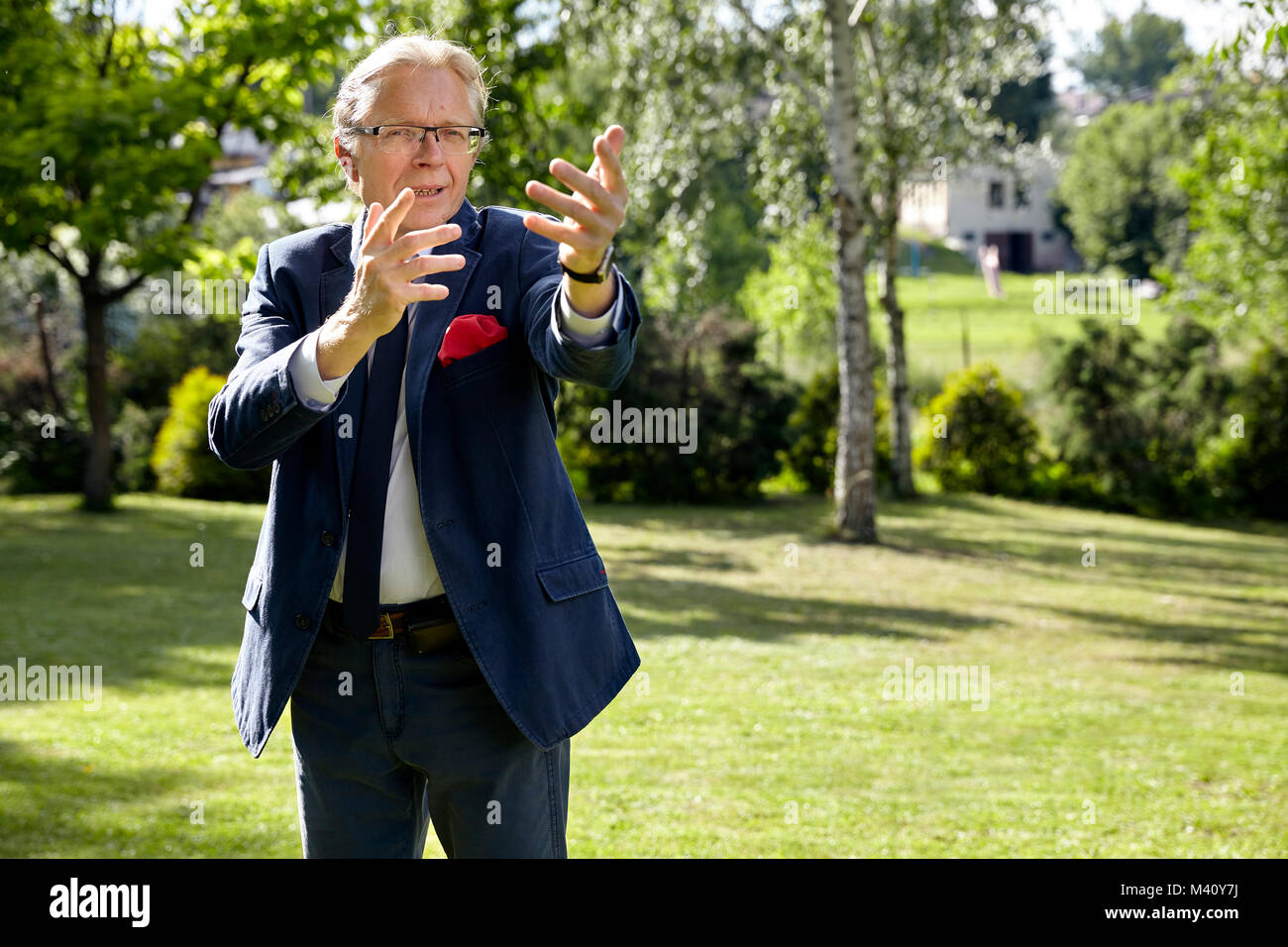 Portrait of gesticulate man in the garden at sunny day. Natural ...