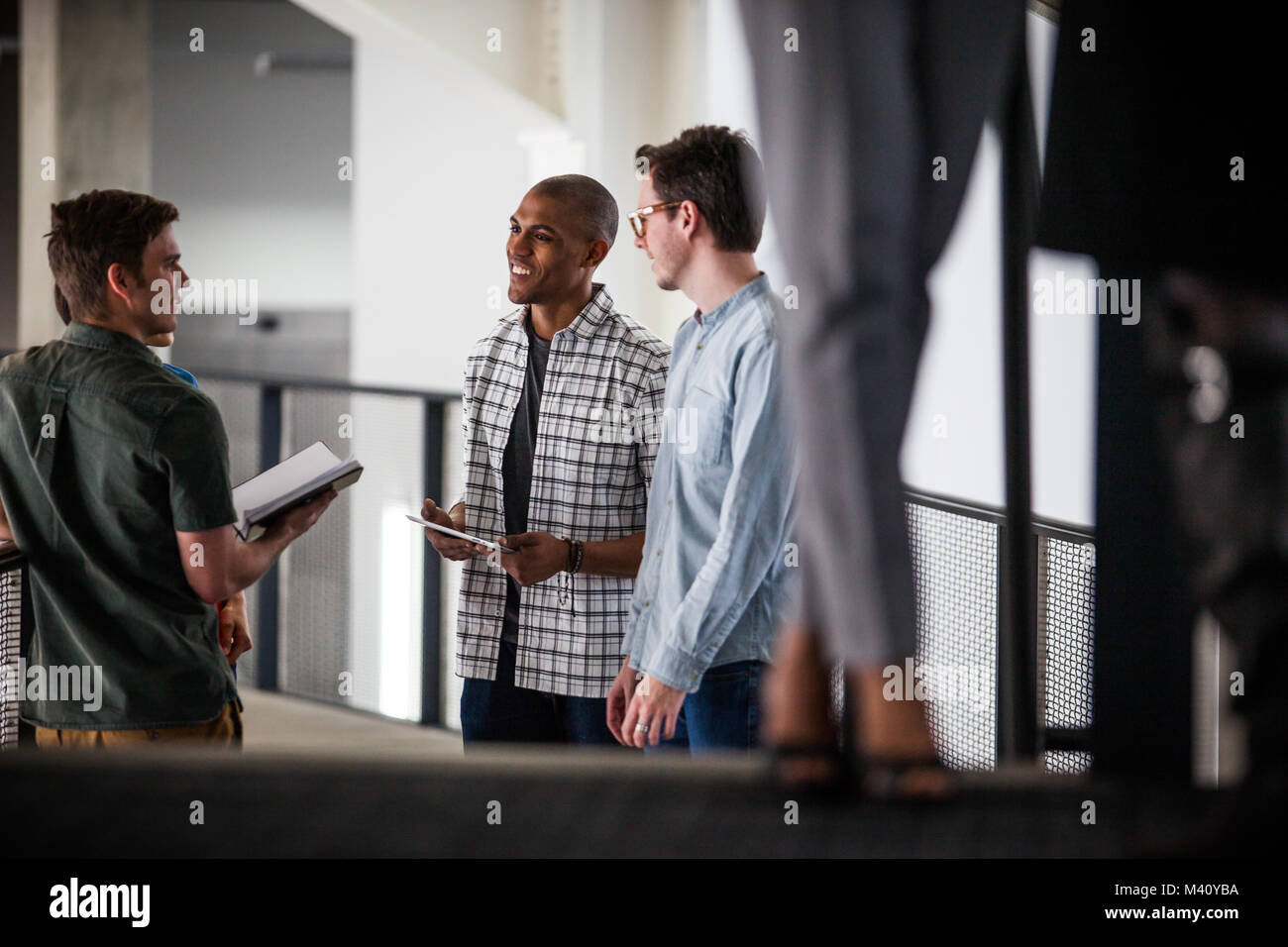 Colleagues talking in a corridor Stock Photo - Alamy