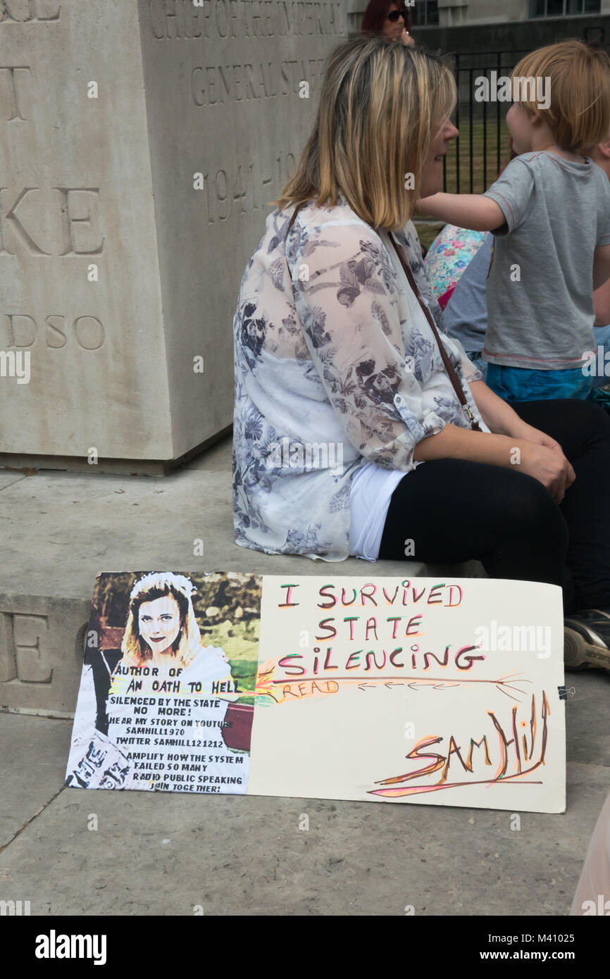 A poster at the rally opposite Downing St calls attention to the stroy ...