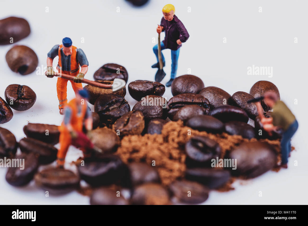 Miniature figures working on coffee macro photography on white ...