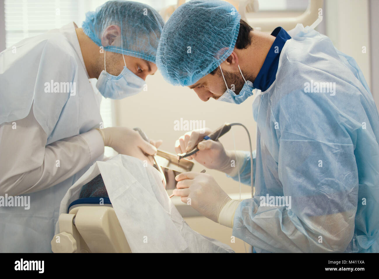 Doctor dentist and assistant during stomatology operation Stock Photo ...