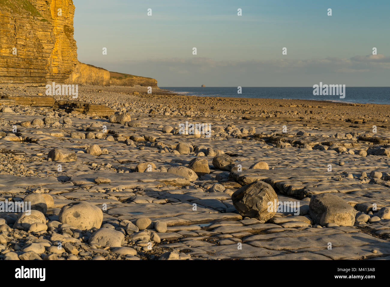 The stones and cliffs of Llantwit Major Beach in the evening sun, South ...