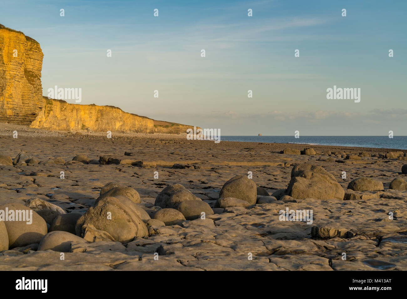 The stones and cliffs of Llantwit Major Beach in the evening sun, South ...