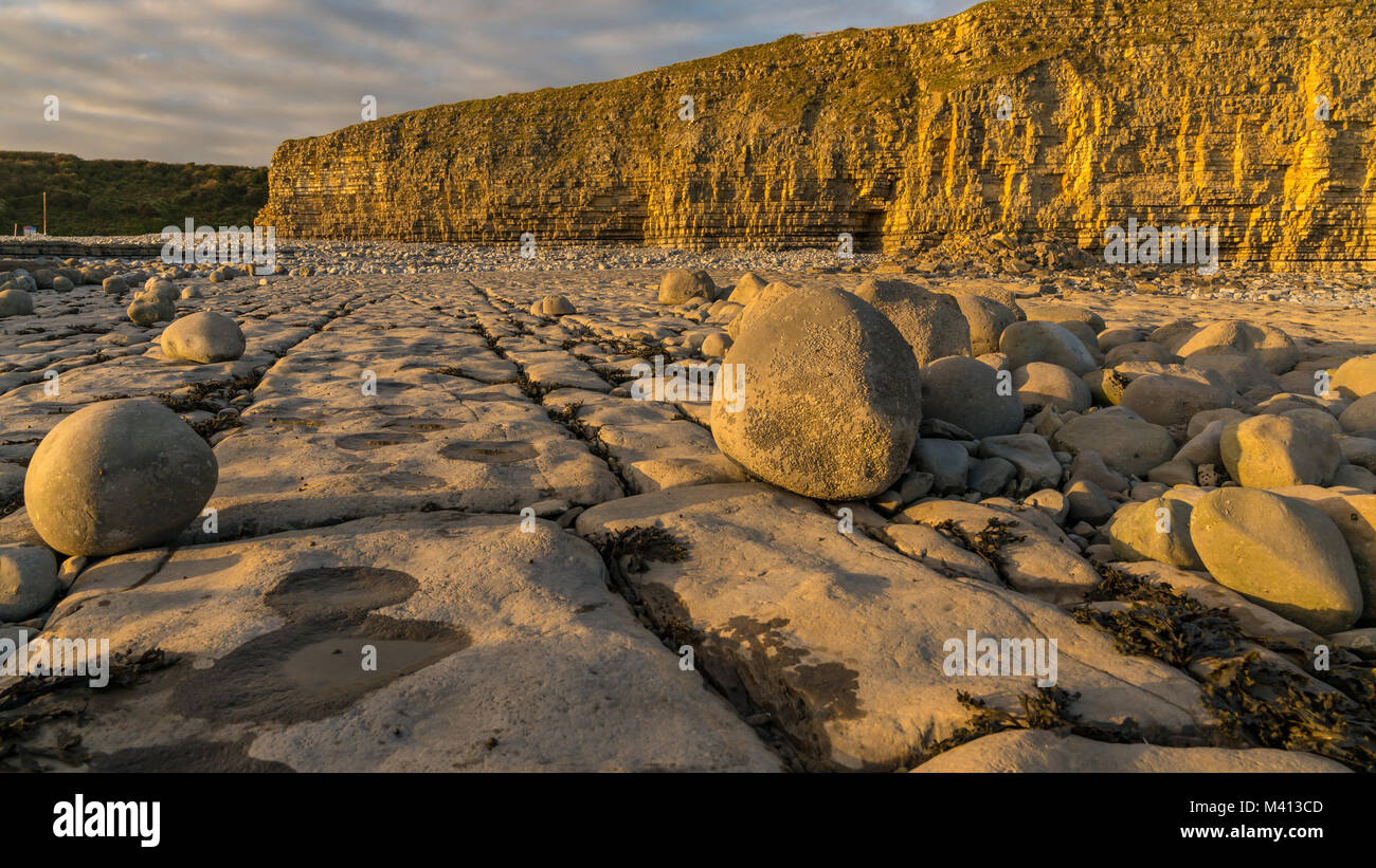 The stones and cliffs of Llantwit Major Beach in the evening sun, South ...