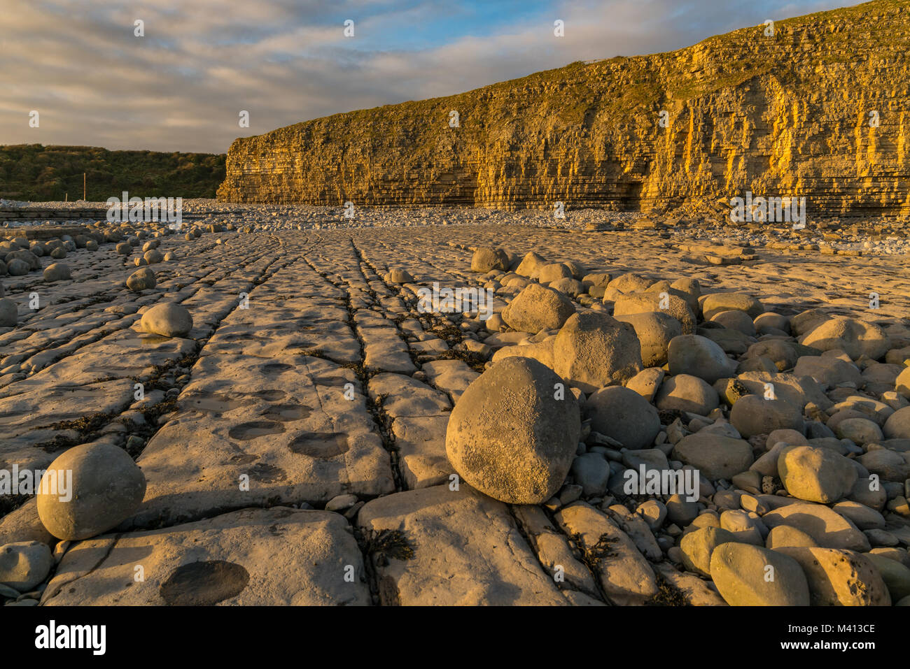 The stones and cliffs of Llantwit Major Beach in the evening sun, South ...