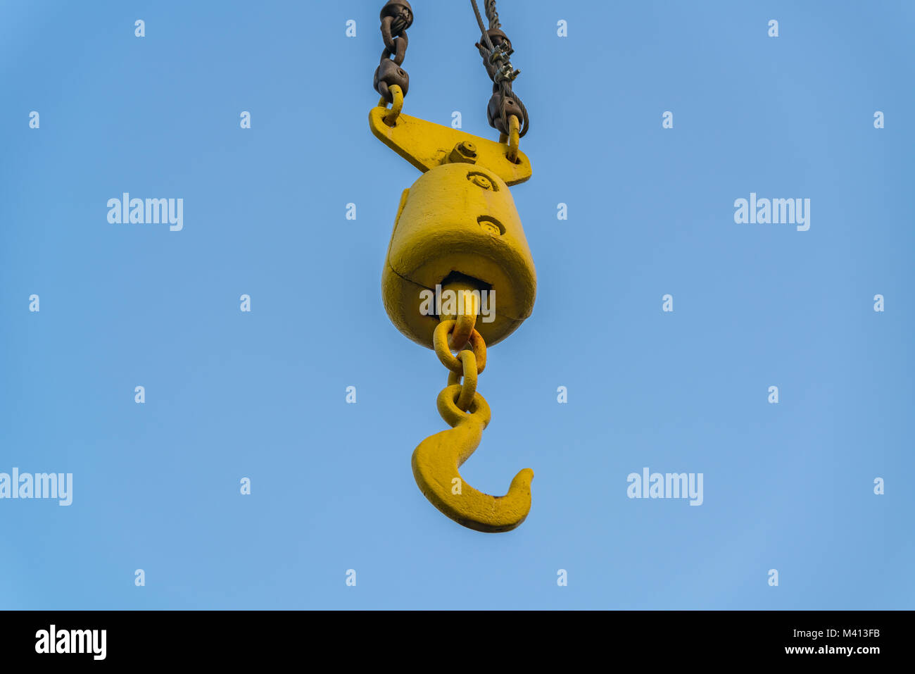 Yellow crane hook with blue sky, seen in Duisburg-Ruhrort, North Rhine ...