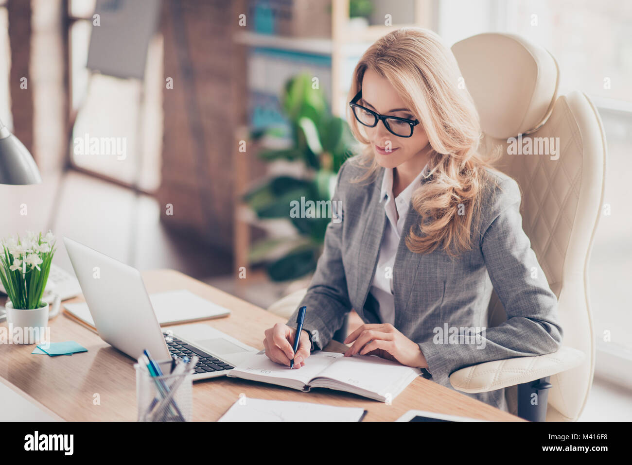 Portrait of stunning busy director sitting at her desk in workstation ...