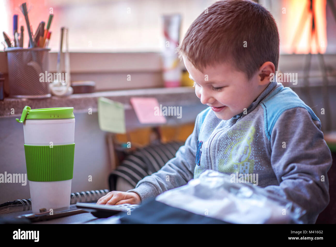 Cute little baby boy using a calculator Stock Photo - Alamy