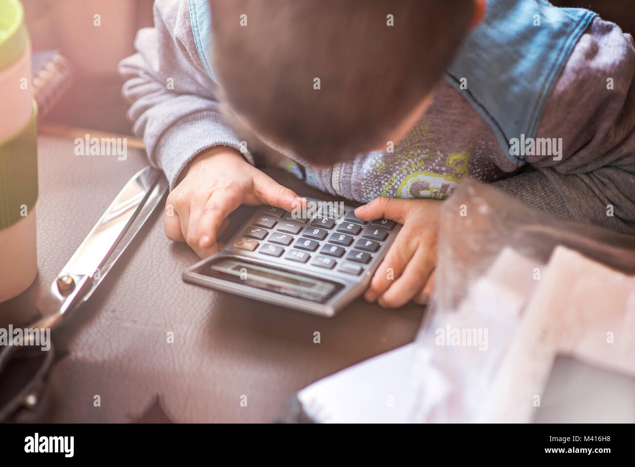 Cute little baby boy using a calculator Stock Photo - Alamy