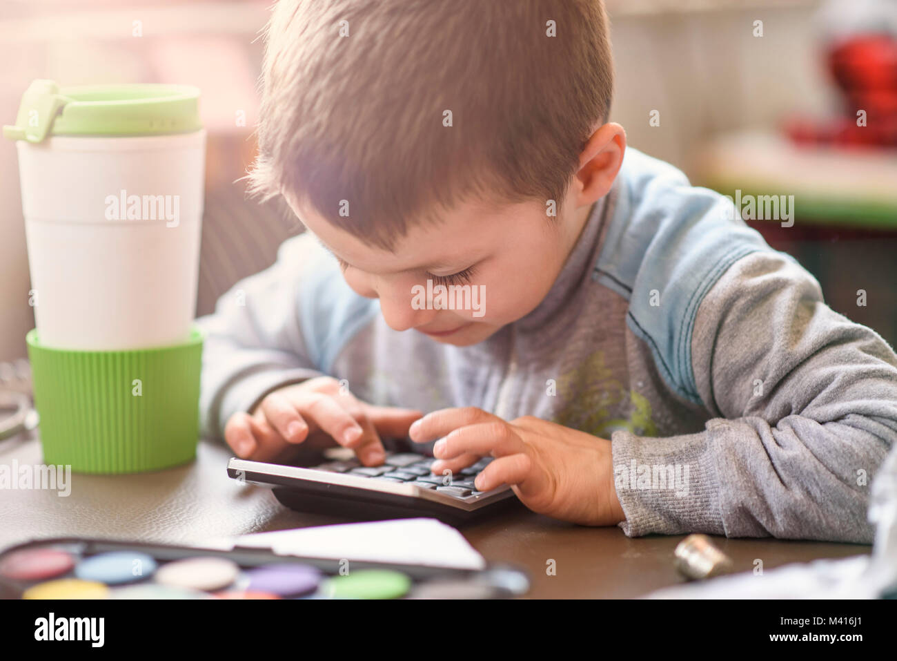 Cute little baby boy using a calculator Stock Photo - Alamy