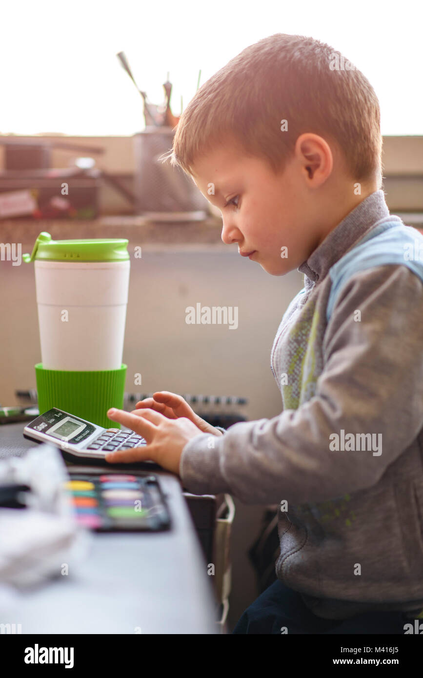 Cute little baby boy using a calculator Stock Photo - Alamy