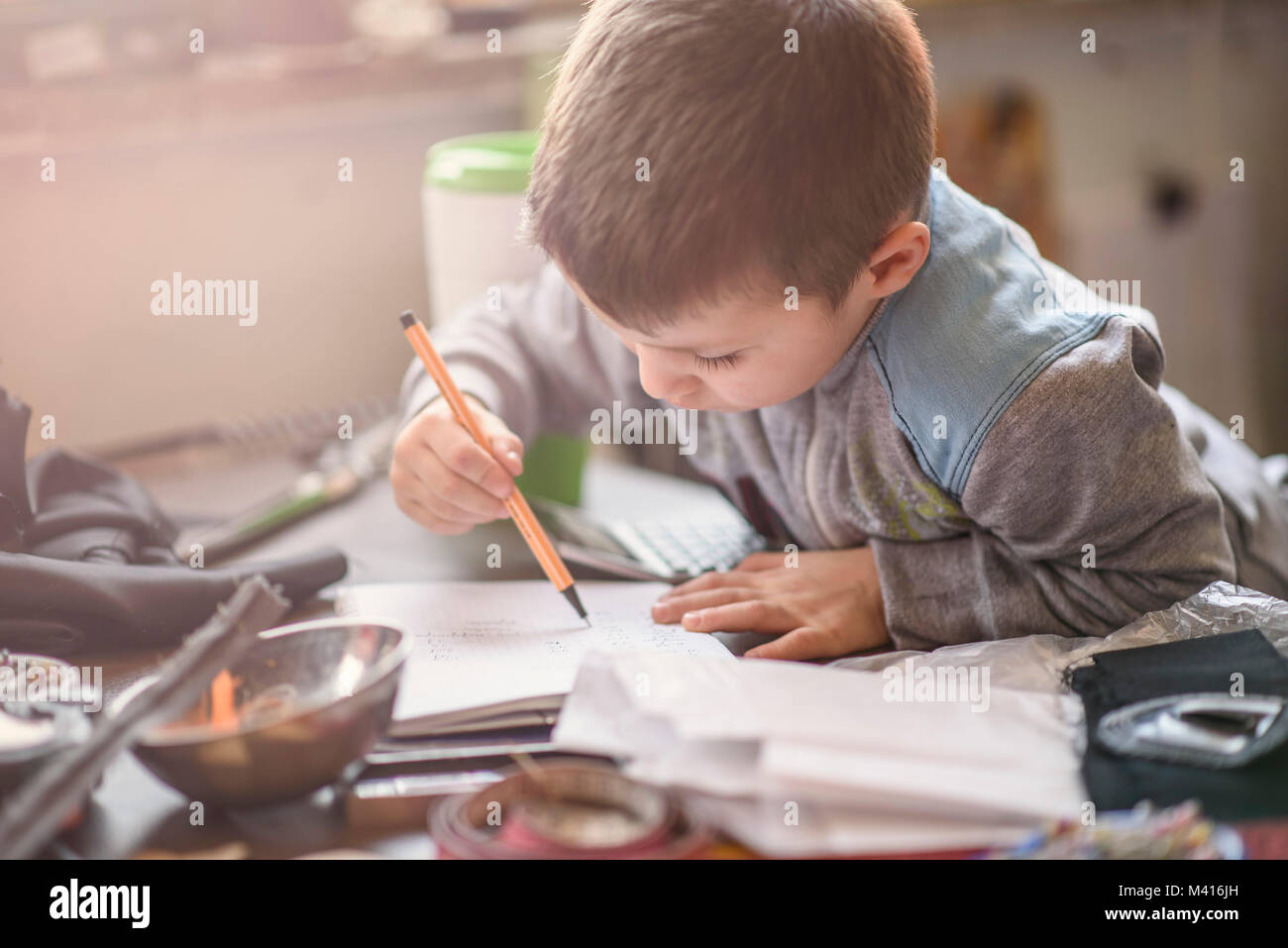Young boy writing words in a notebook Stock Photo - Alamy