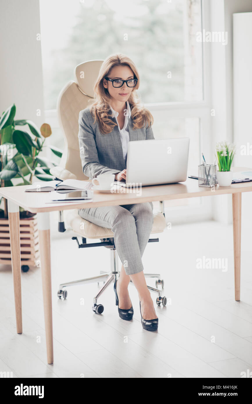 Full length portrait of pretty, charming, blonde woman using, browsing ...