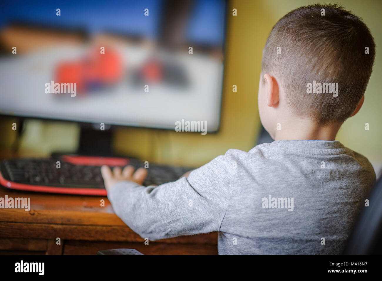 Young boy playing games on a desktop computer Stock Photo - Alamy