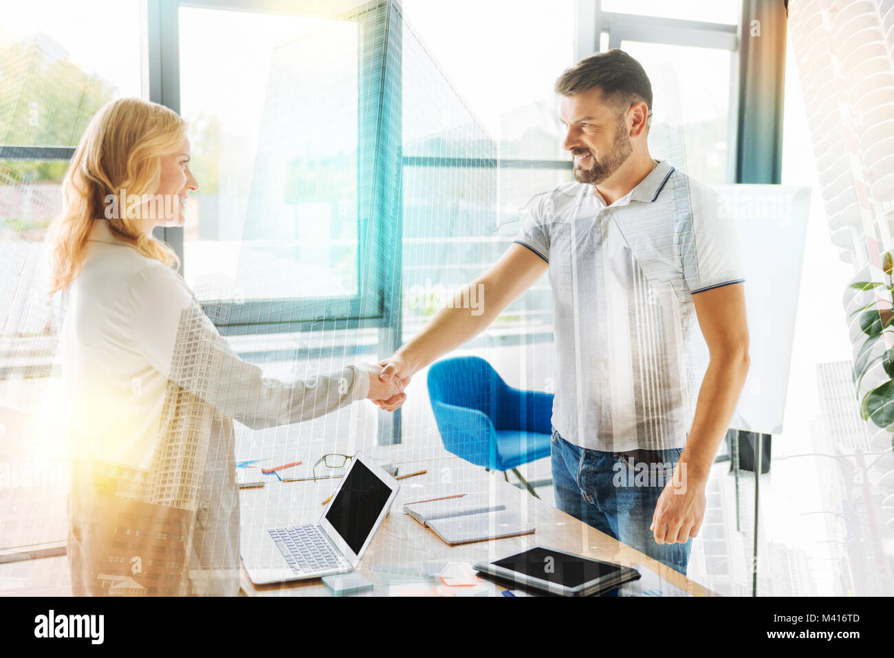 Clever coworkers smiling while shaking hands in their office Stock ...