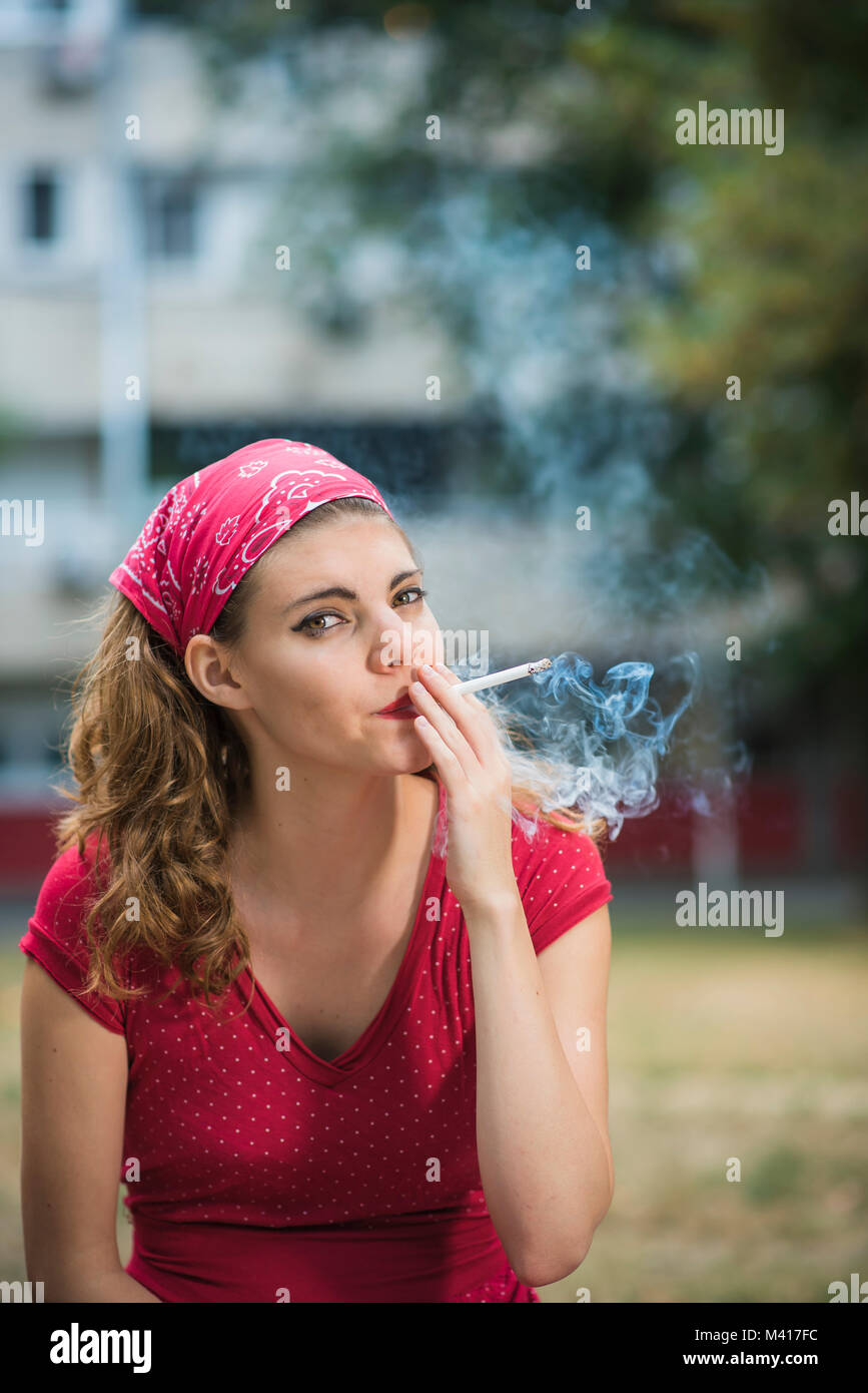 Red retro girl smoking in the park Stock Photo - Alamy