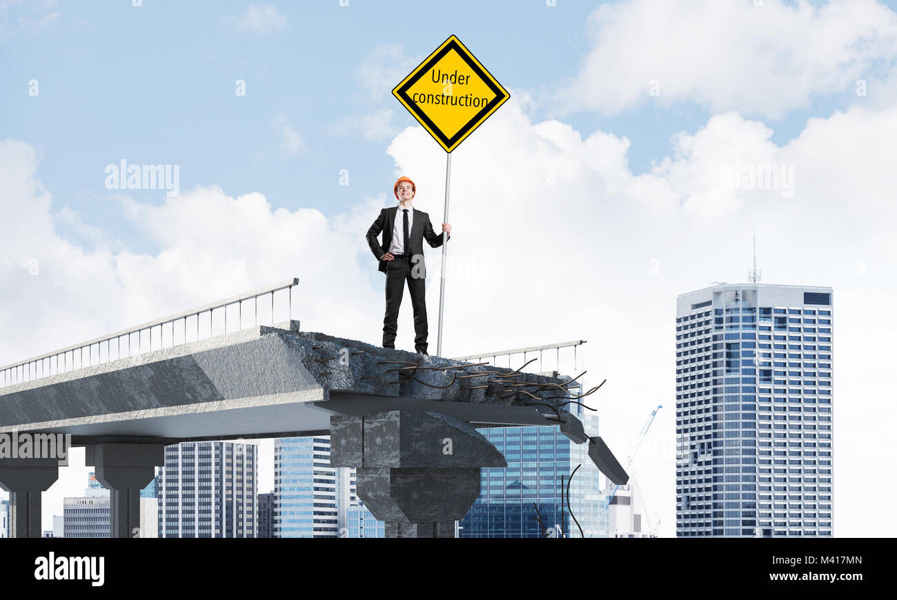 Confident engineer holding street safety sign Stock Photo - Alamy